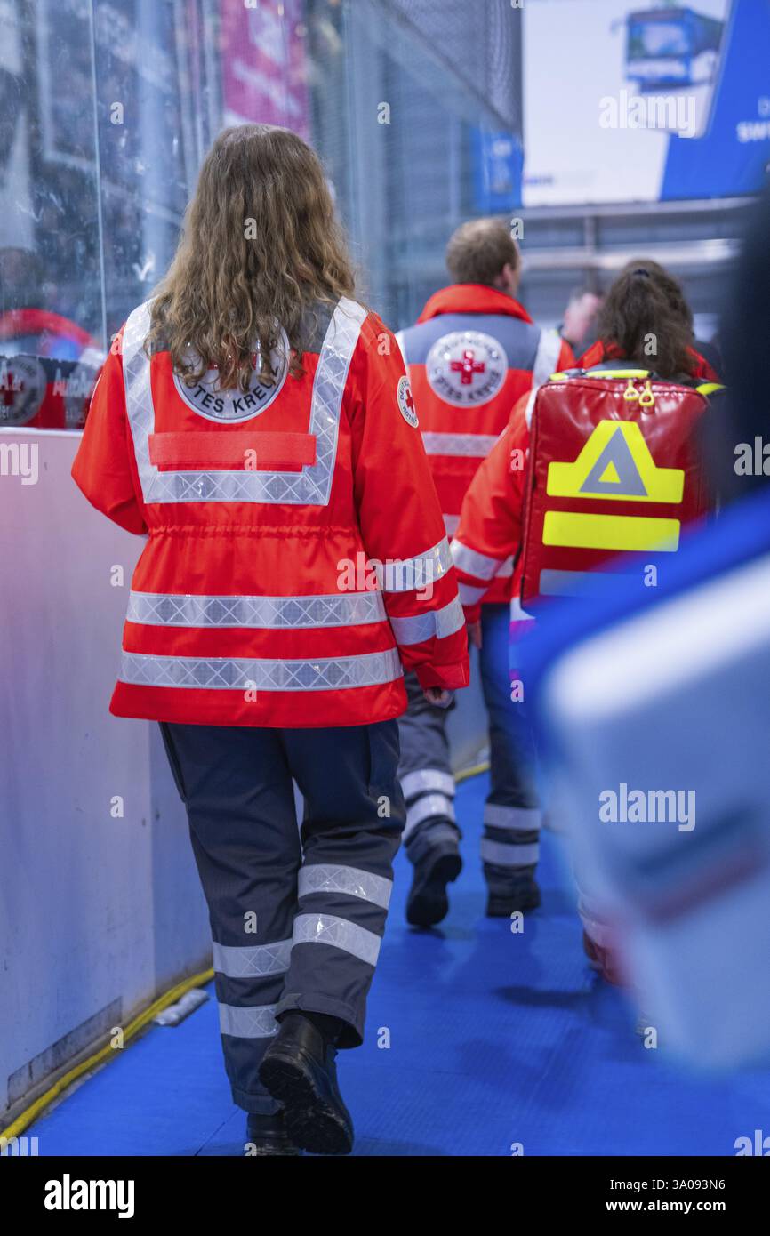 Rescue workers in red jackets walk through a sports hall, Heilbronner ...