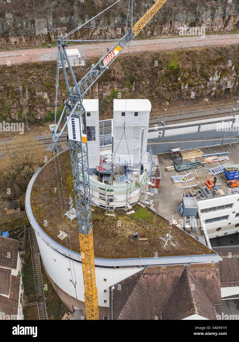 Construction project on a round building with crane and materials in an ...