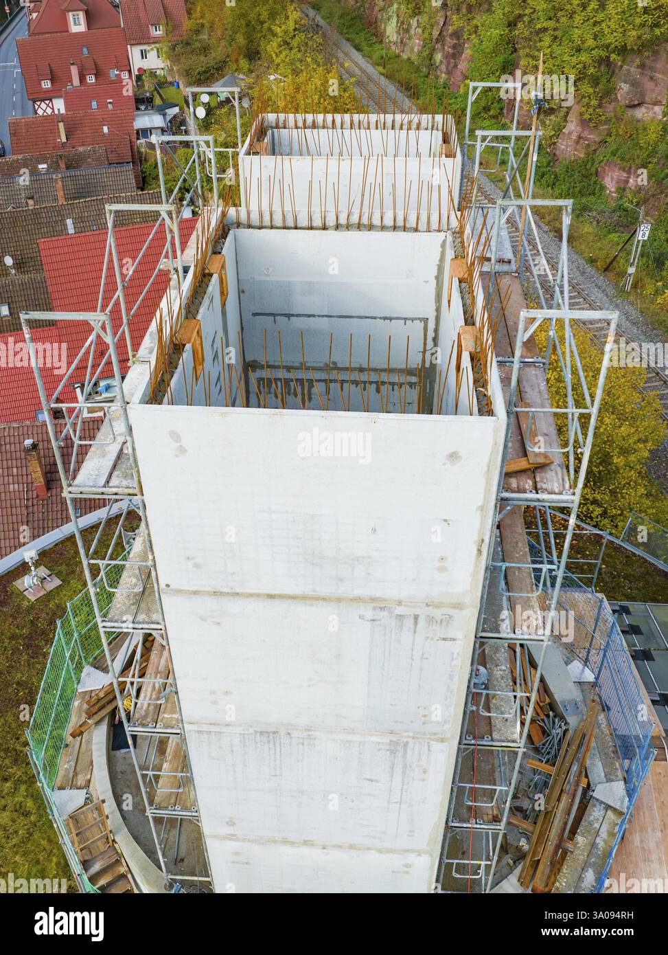 Concrete tower with scaffolding in the middle of red house roofs and ...