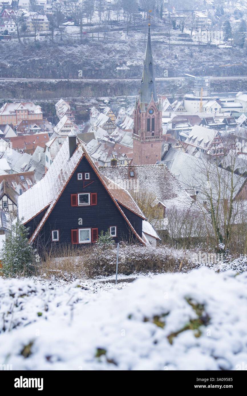 Winter village landscape with snow-covered roofs and striking church ...