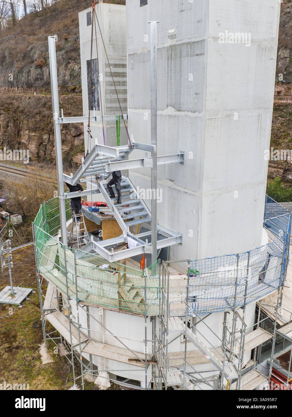 Workers on a construction site with concrete towers and metal ...