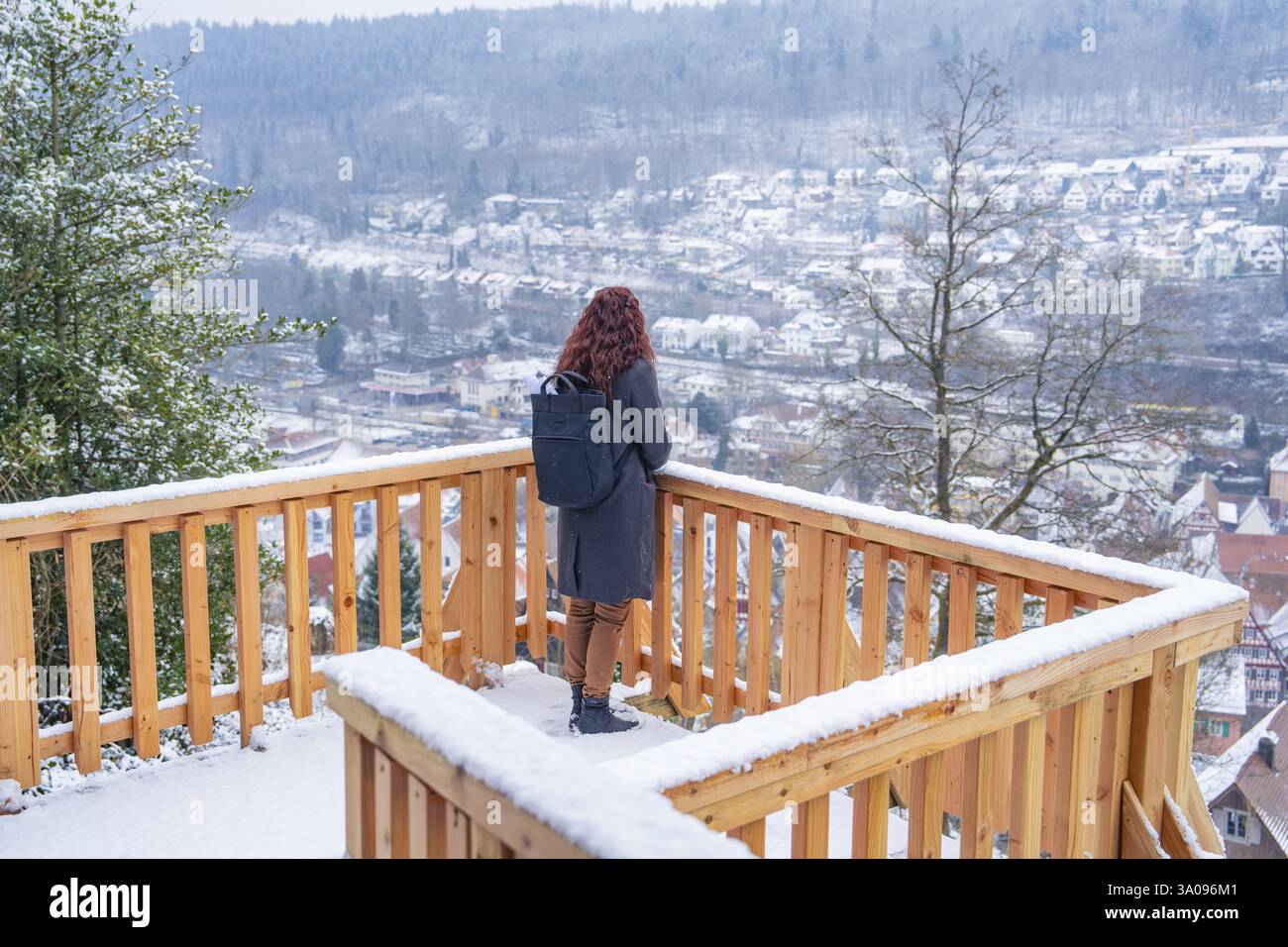 View of a snowy winter landscape from a vantage point with wooden fence ...