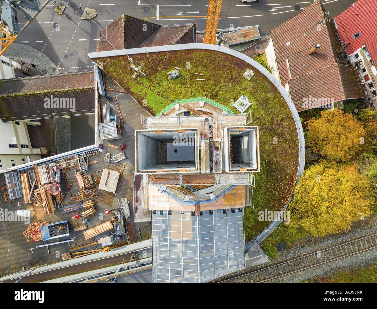 Roof-covered construction site with open concrete tower, surrounded by ...