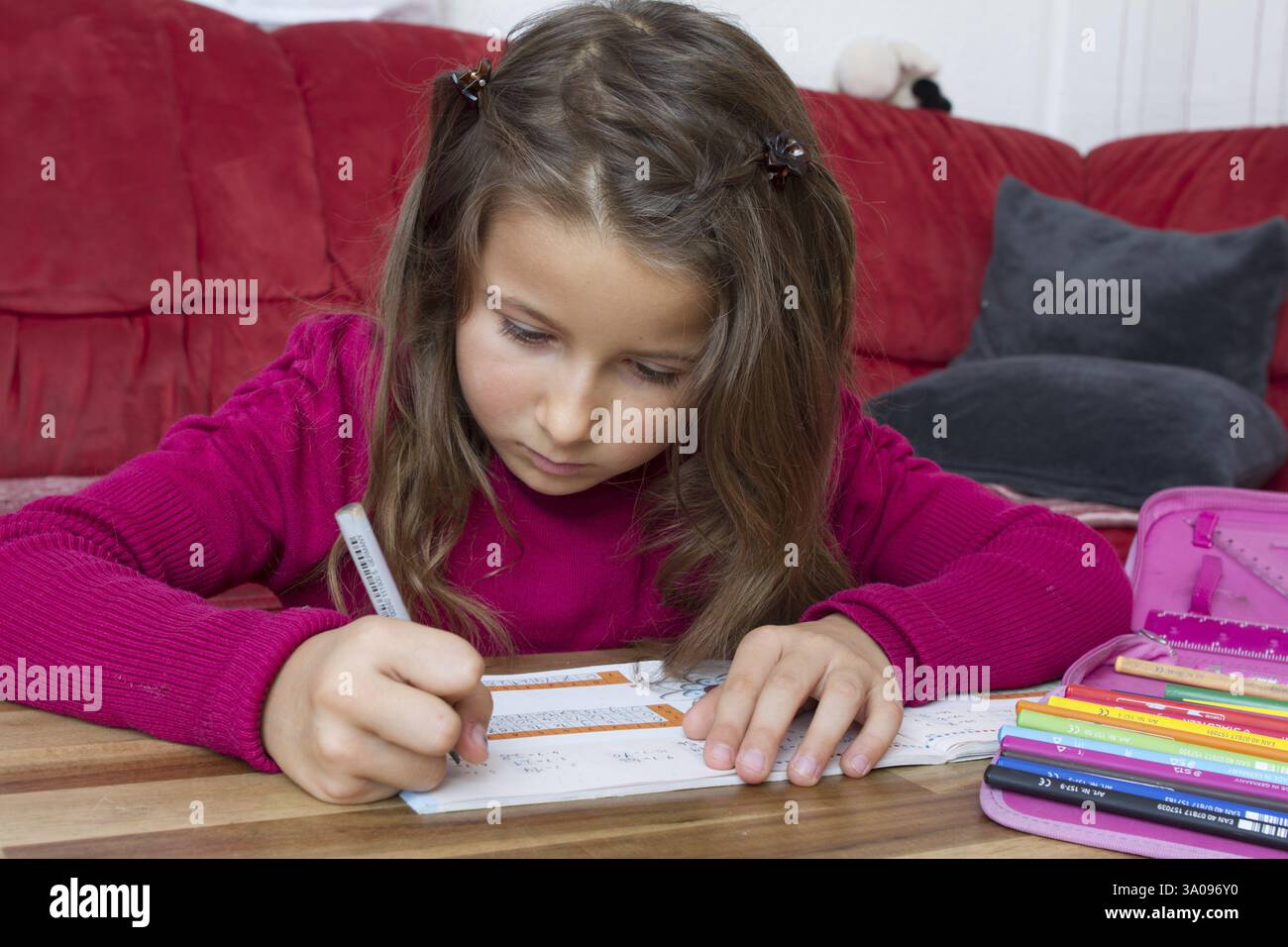 Seven-year-old does schoolwork, 7 years, girl, sofa, writes, exercise ...