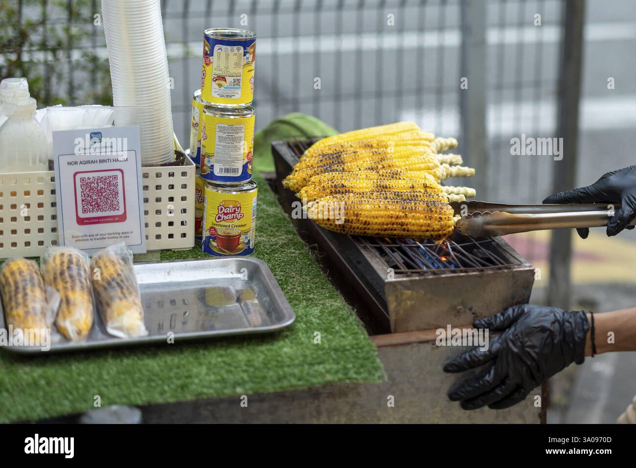Grilling corn, by the roadside, Bukit Bintang neighbourhood, Kuala ...