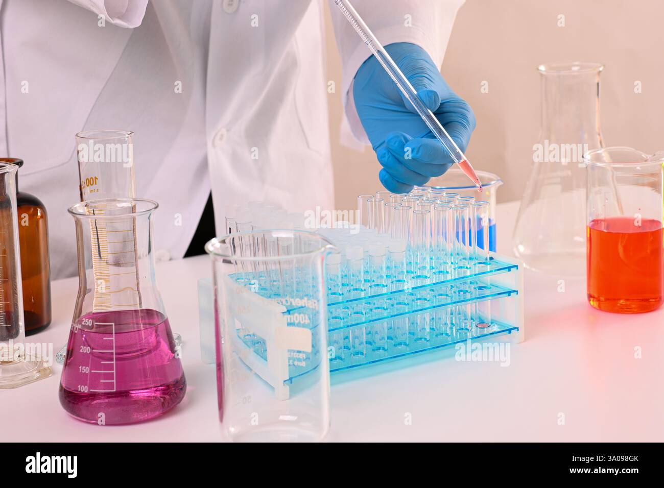 Scientist conducting experiment using micropipette, adding reagent to ...