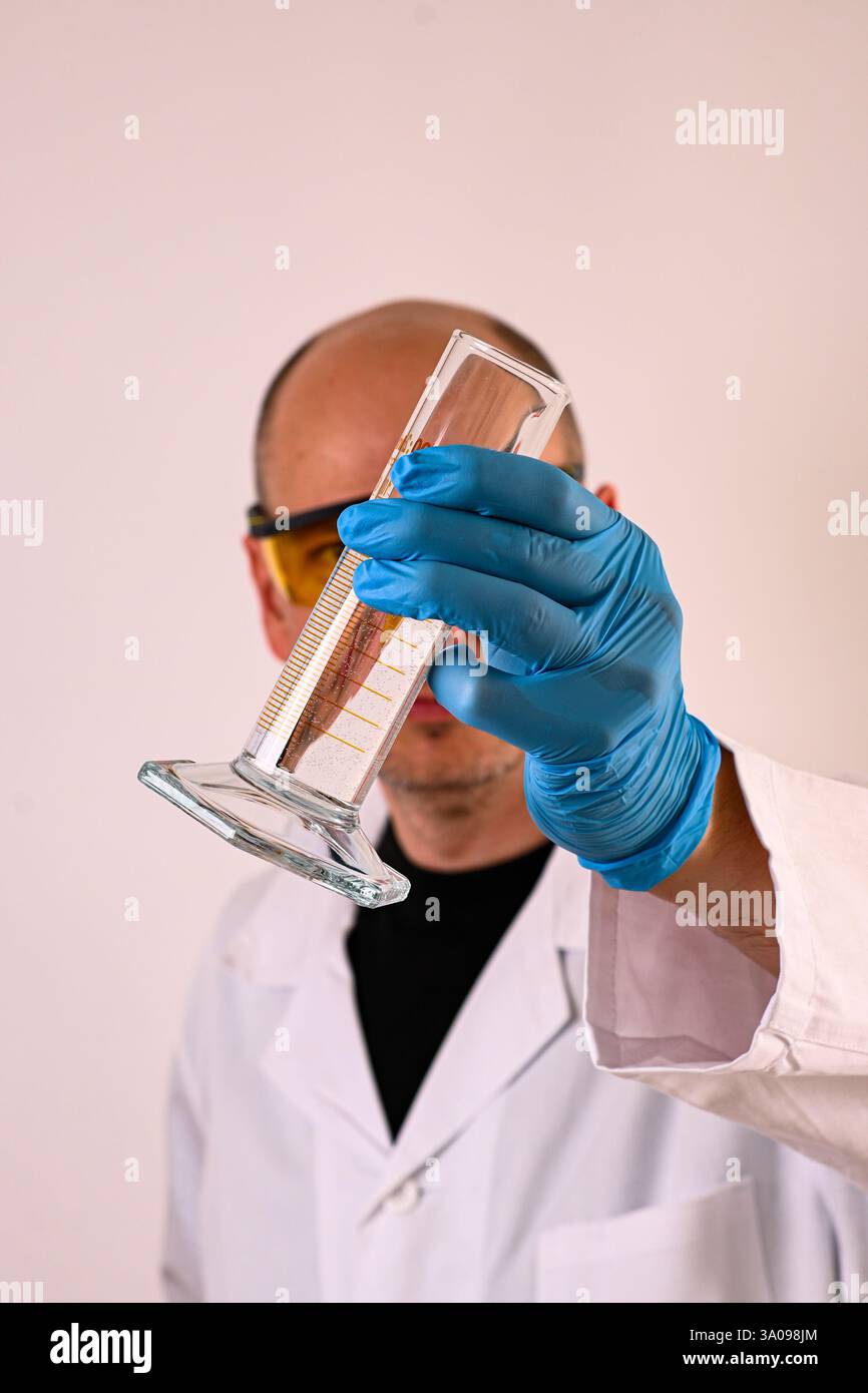 Scientist analyzing liquid solution in graduated cylinder, conducting ...