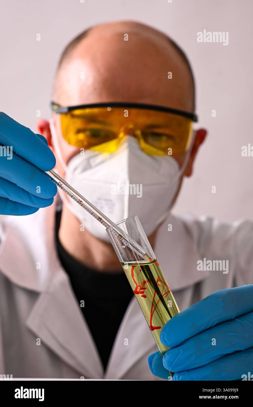 Scientist wearing protective glasses and mask measuring temperature of ...