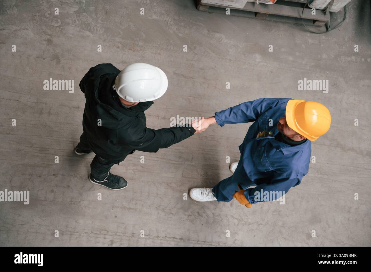 Two industrial workers are doing handshake. Top view. Successful ...