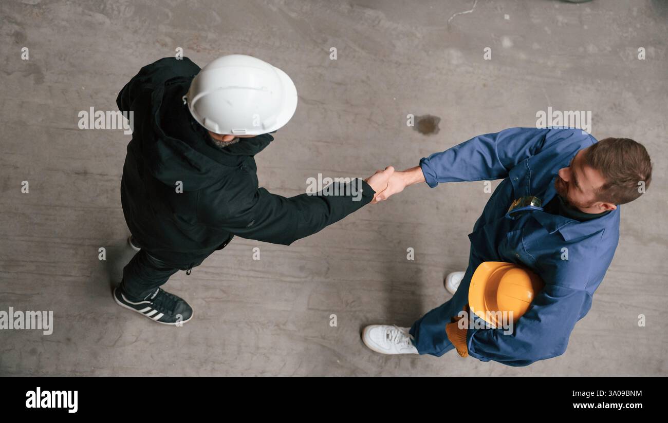 Two industrial workers are doing handshake. Top view. Successful ...