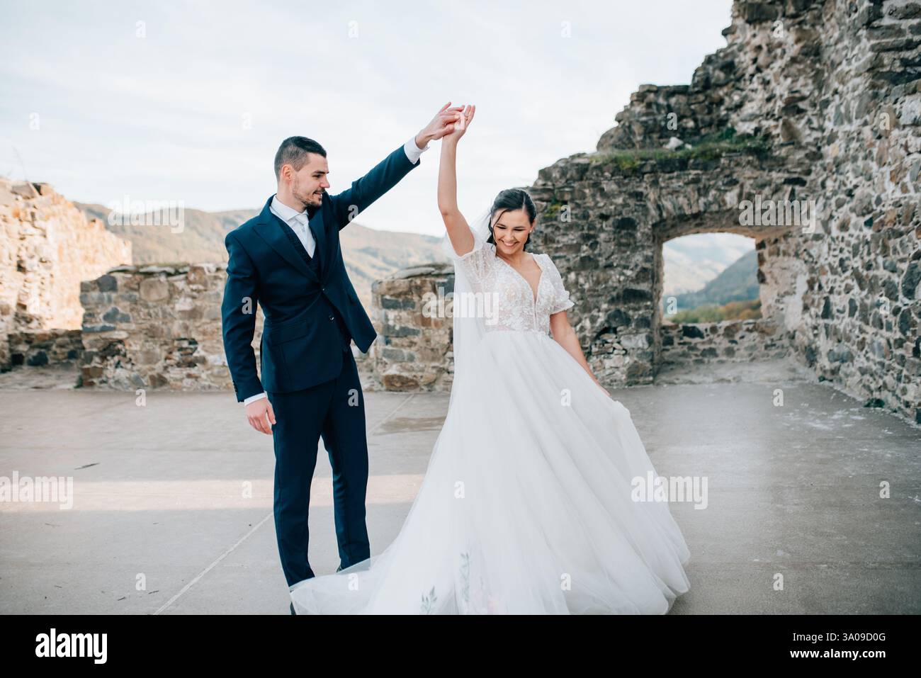 Bride and groom dancing, looking at each other. Wedding couple standing ...