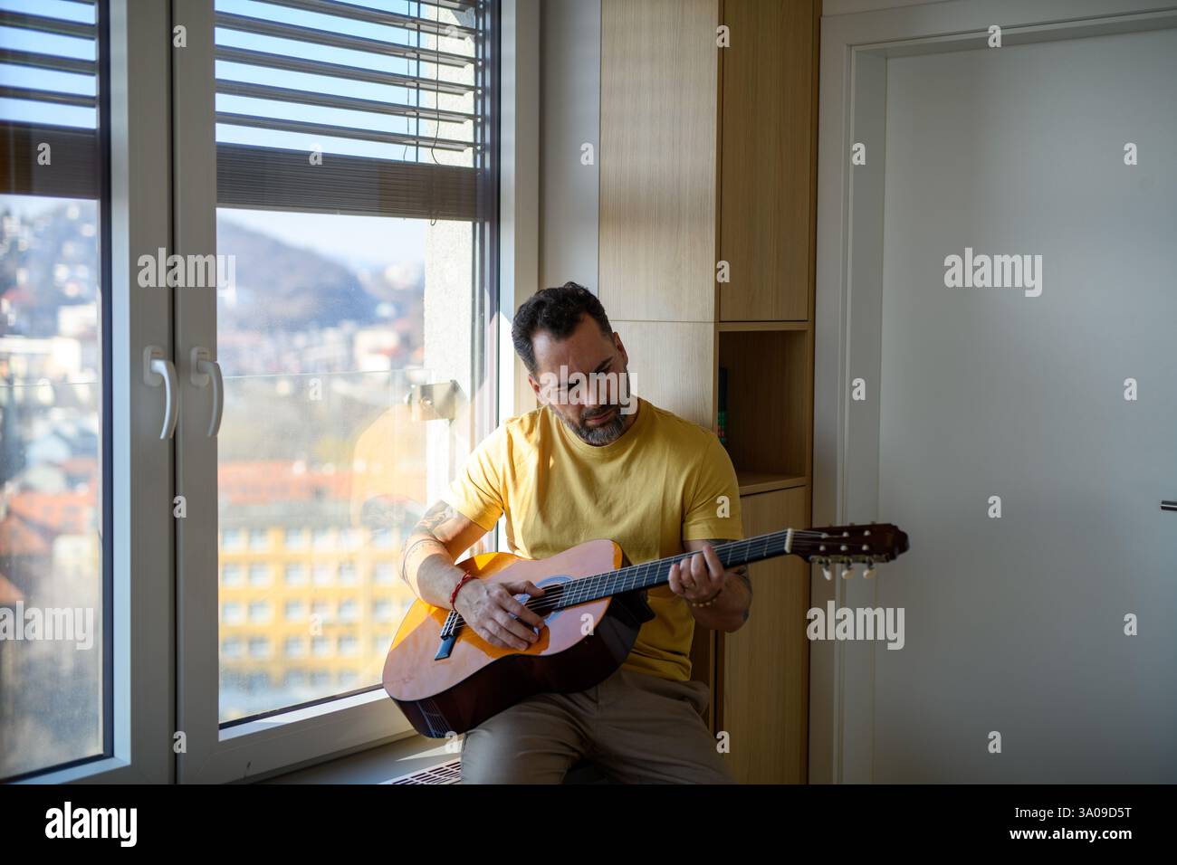 Diabetic man with CGM sensor on arm playing on guitar Stock Photo - Alamy