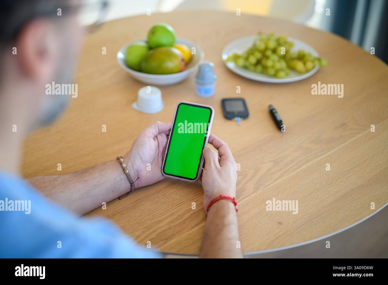 Man is checking blood glucose level using smartphone app Stock Photo ...