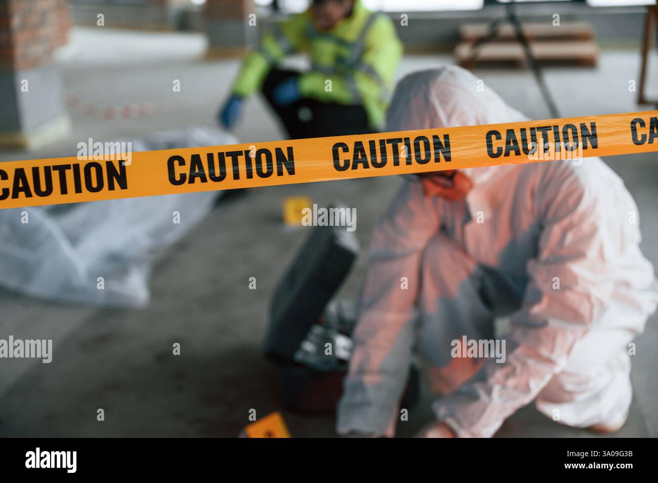 Caution police tape. Detectives are collecting evidence in a crime scene near dead body Stock ...