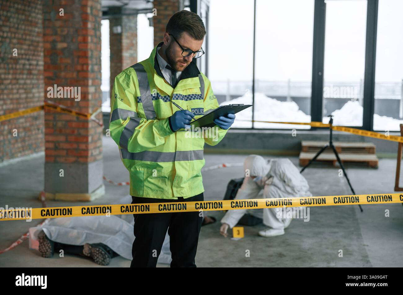 Man writing information into notepad. Detectives are collecting ...