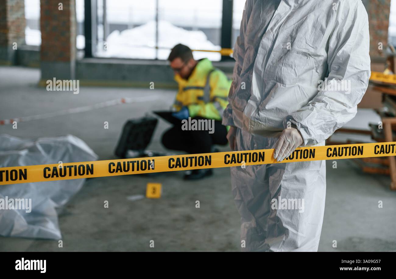 Holding caution police tape. Detectives are collecting evidence in a ...