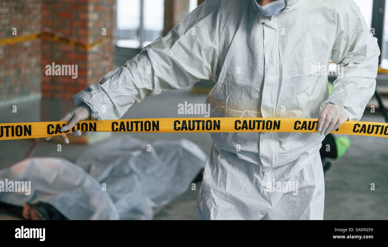 Holding caution police tape. Detectives are collecting evidence in a ...