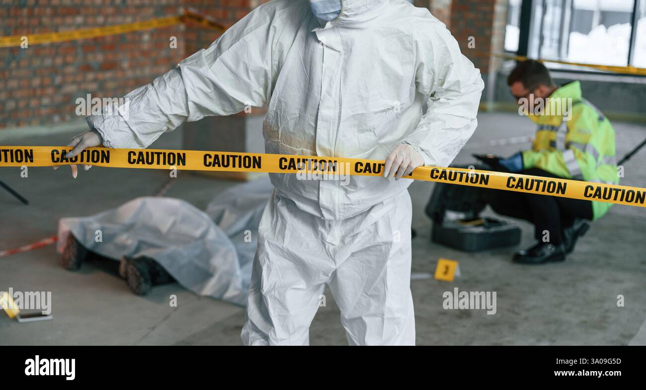 Holding caution police tape. Detectives are collecting evidence in a ...