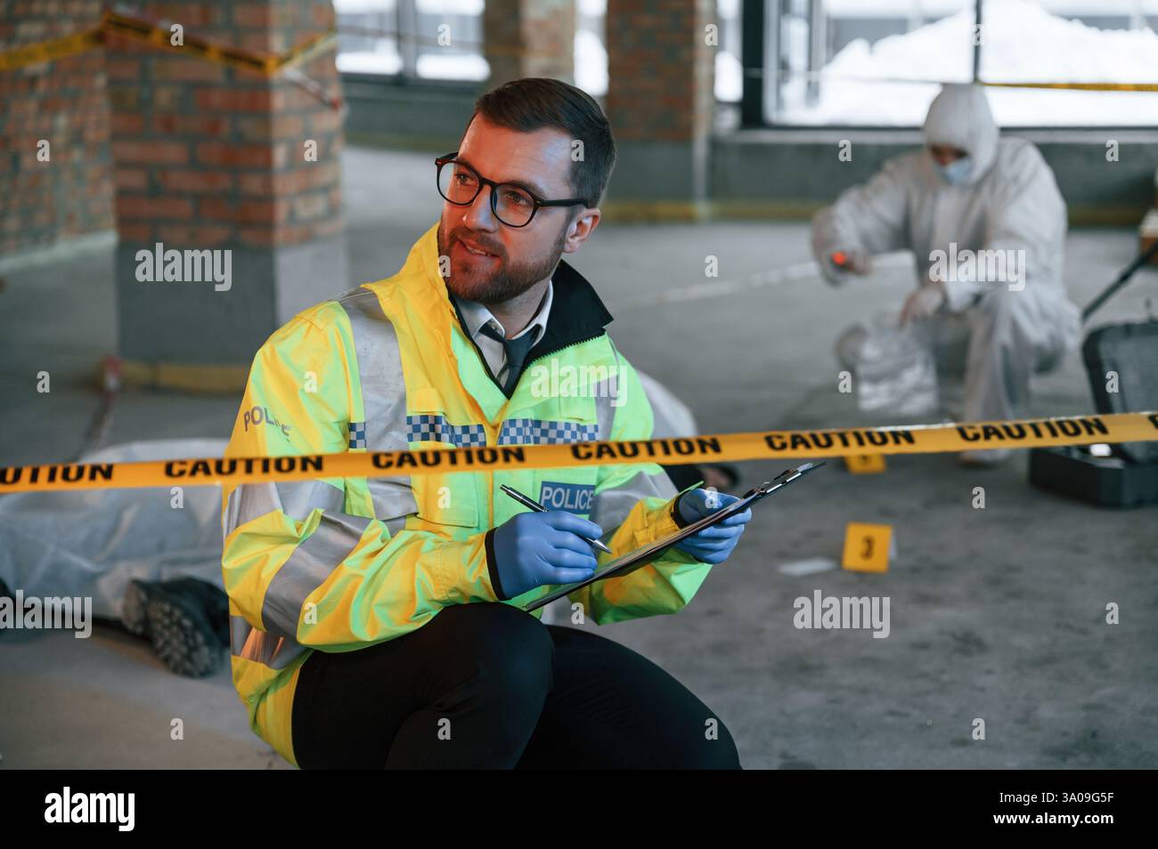 Sitting near caution police tape. Detectives are collecting evidence in ...