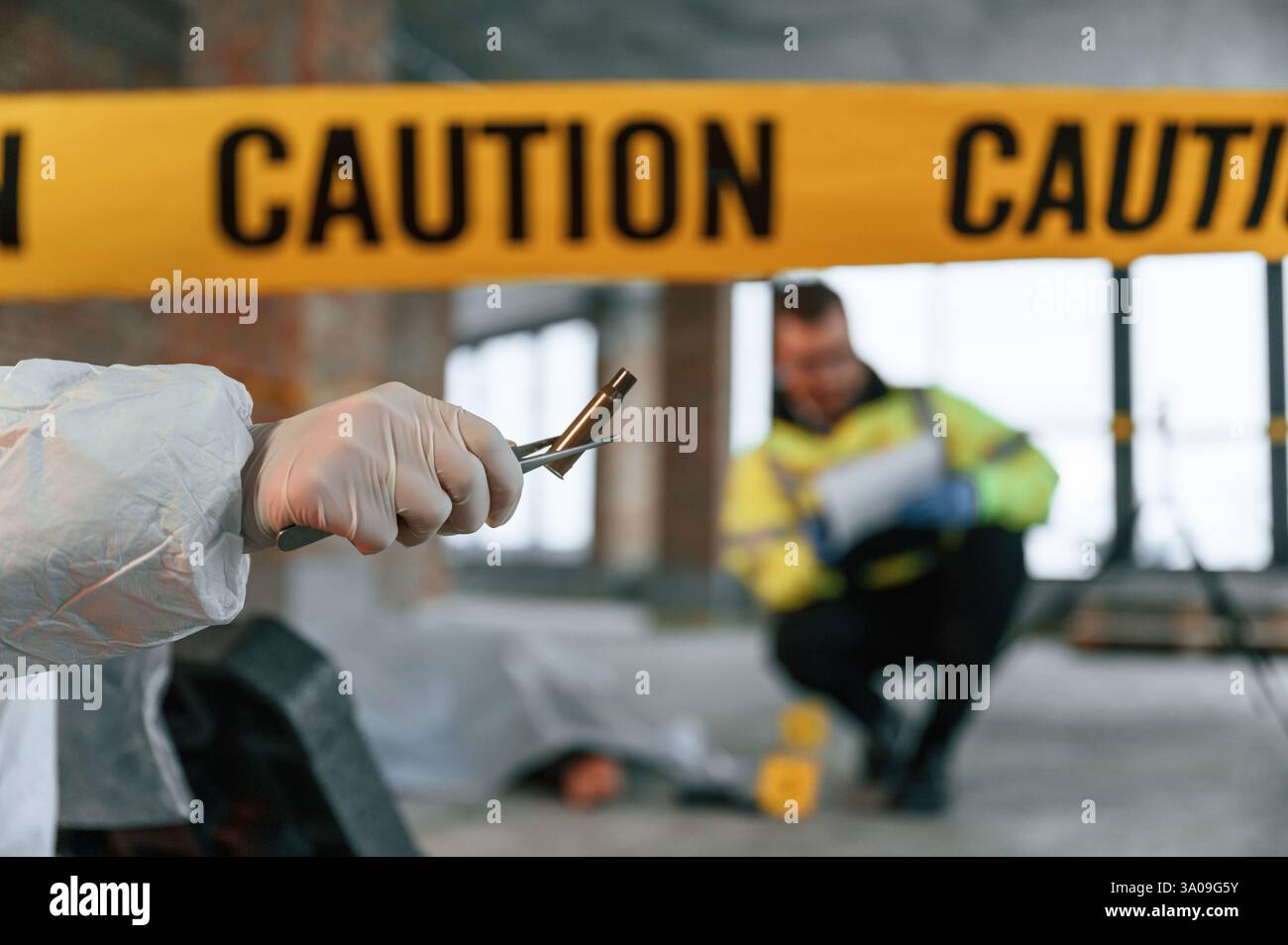 Bullet sleeve in hand. Detectives are collecting evidence in a crime ...