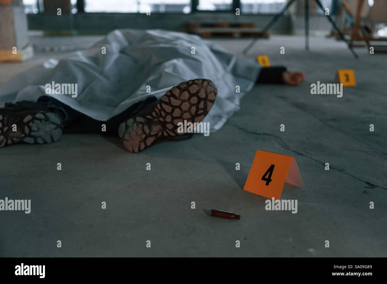 Bullet shell as clue. Dead body of a man is on the ground, covered in ...