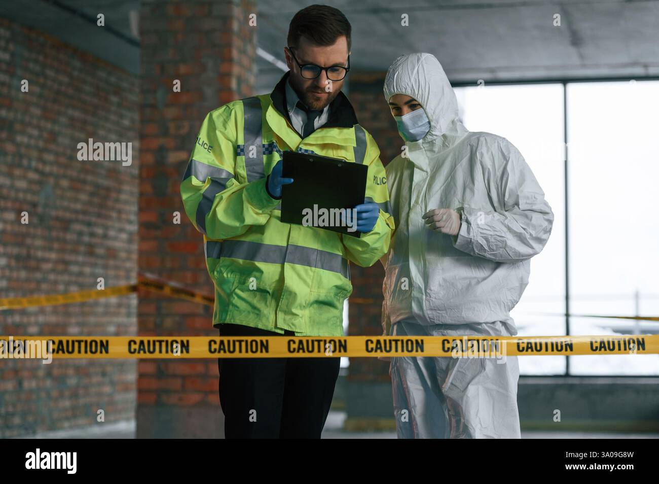 Holding notepad. Two detectives are collecting evidence in a crime ...