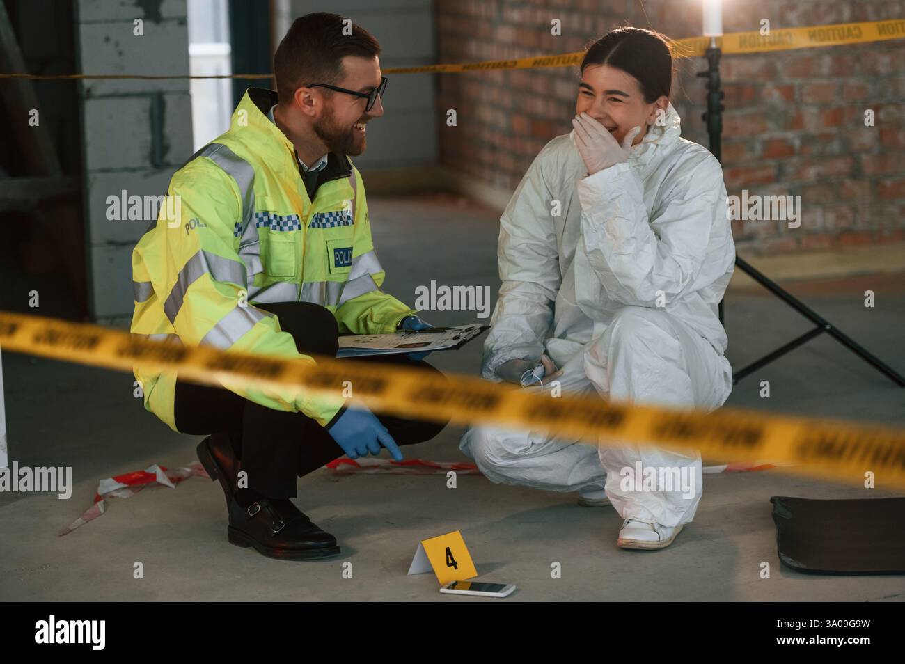 Sitting and laughing. Two detectives are collecting evidence in a crime ...