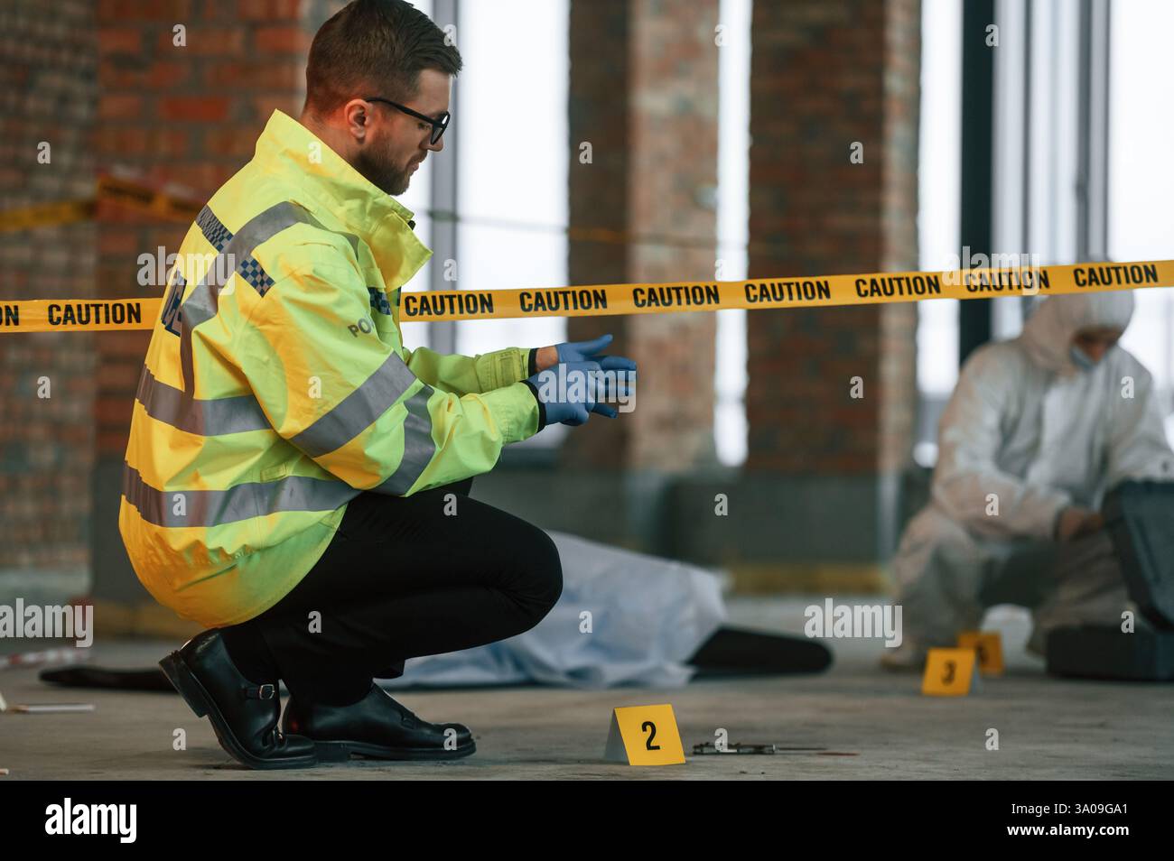 Dead body is on the ground. Detectives are collecting evidence in a ...