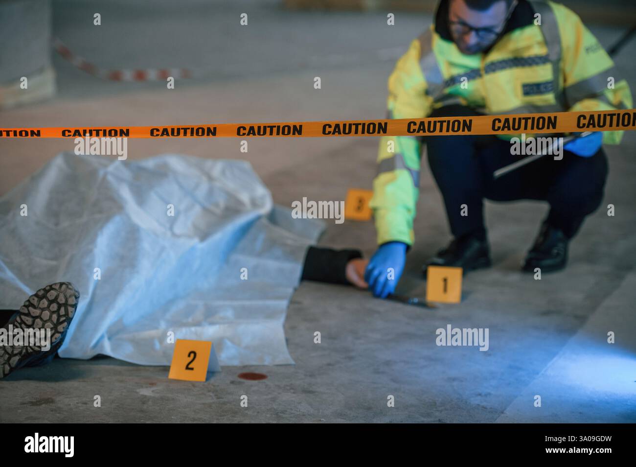 Knife is on the floor. Male detective is collecting evidence in a crime ...