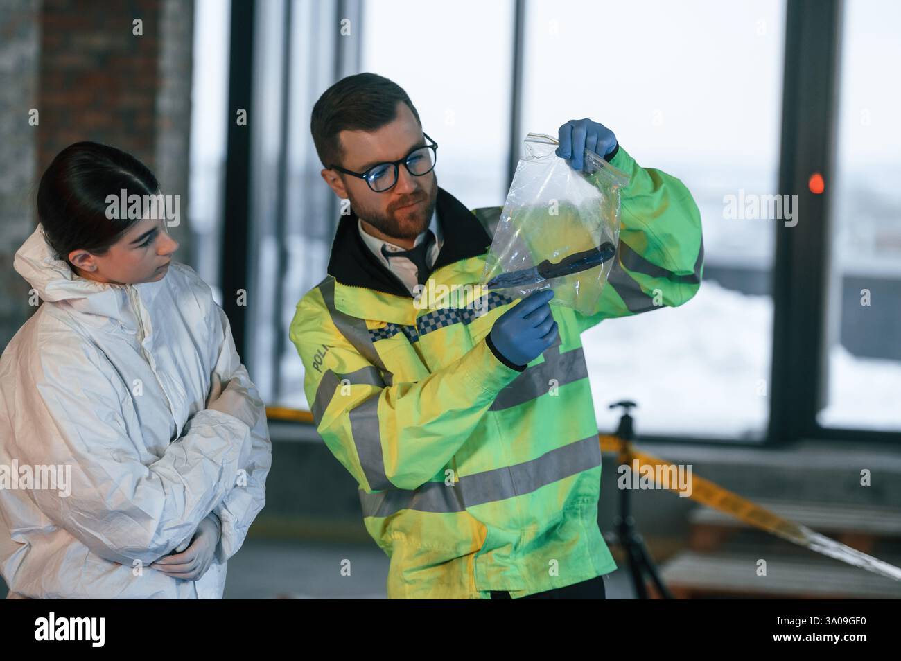 Holding knife in package. Two detectives are collecting evidence in a crime scene Stock Photo ...