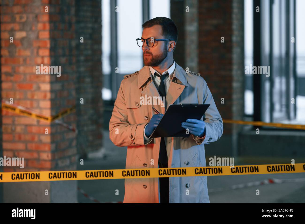 Male detective in coat is collecting evidence in a crime scene on the ...