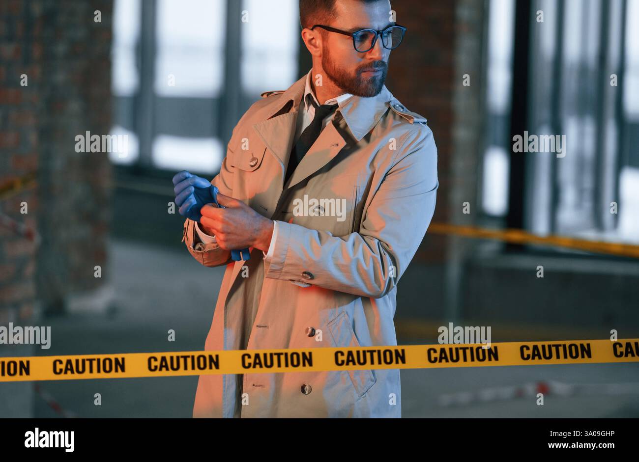 Taking off the gloves. Male detective in coat is collecting evidence in ...