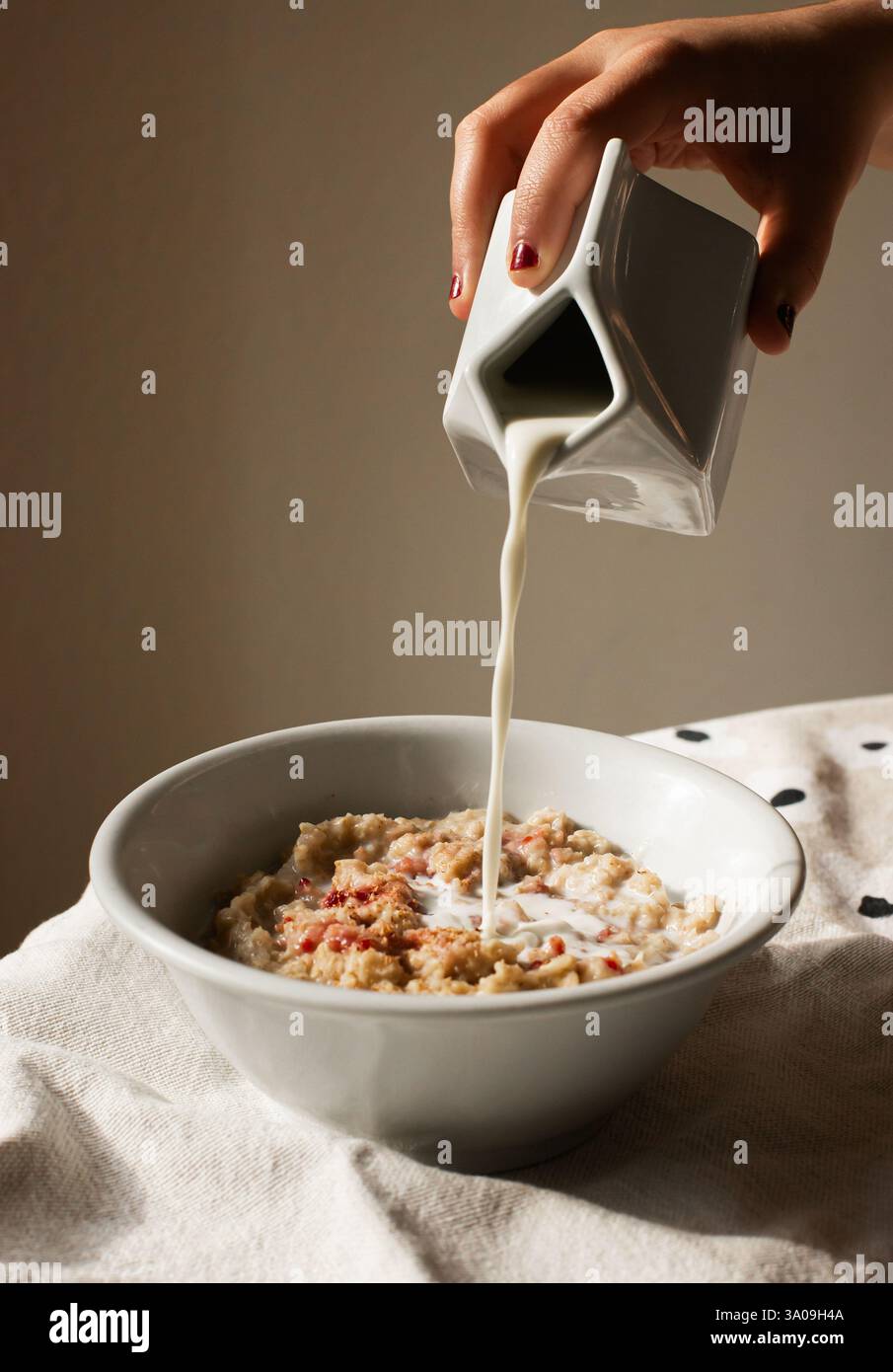 Hand pouring milk bowl cereal hi-res stock photography and images - Alamy