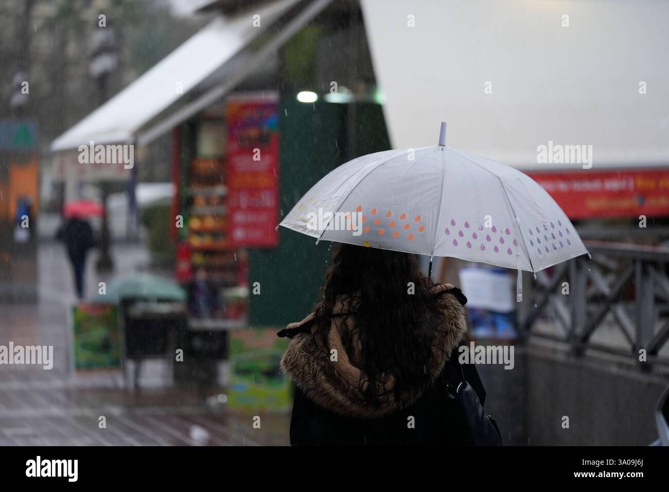 A person protects himself from the rain with an umbrella. On March 03 ...