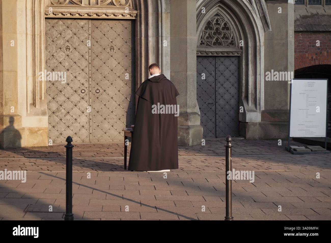 Catholic priest in black robe, cloak praying on church background - 3 ...
