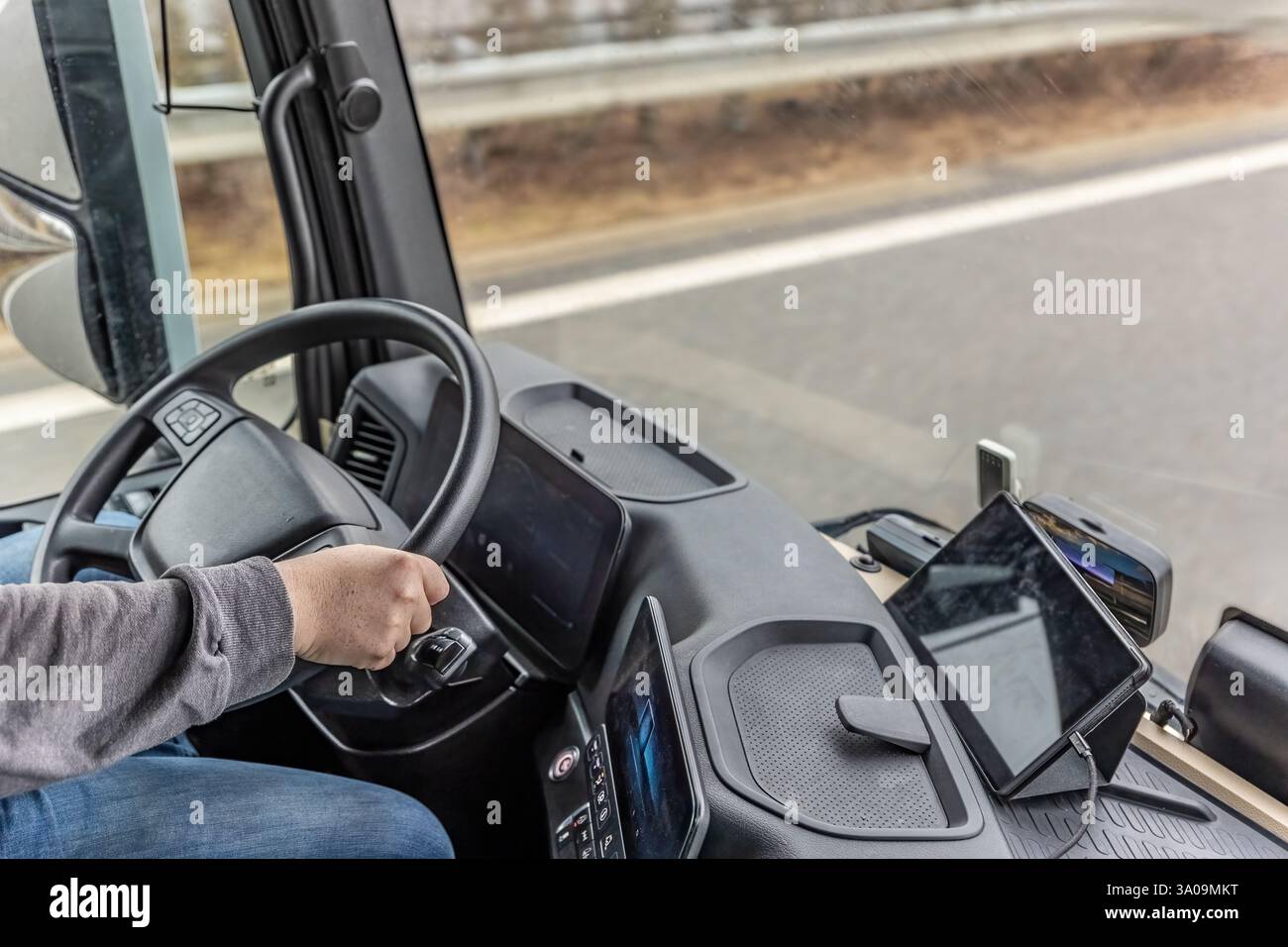 View of part of the driver's body in the cab of a moving truck ...