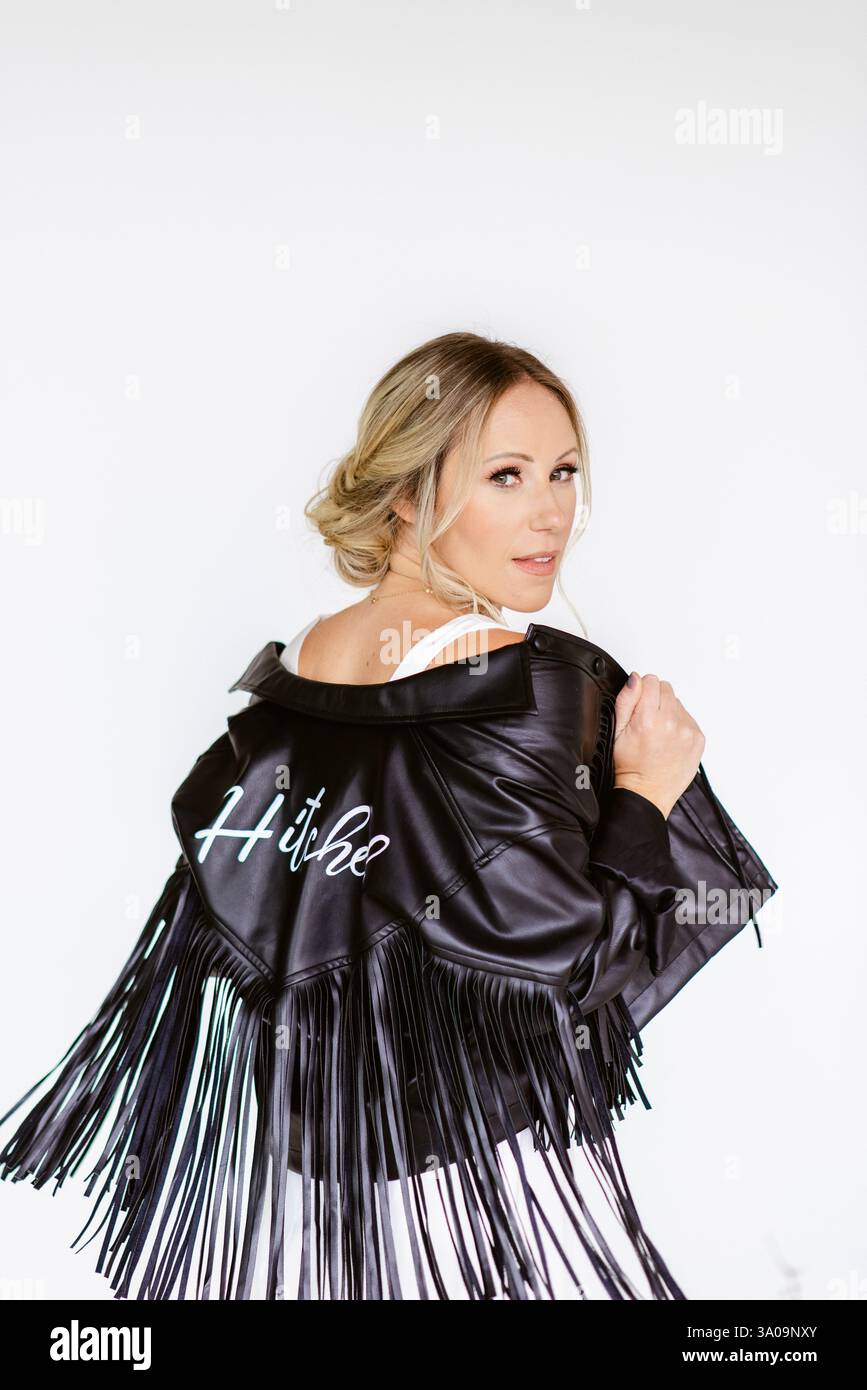 Bride in a black fringe leather jacket with "Hitched" lettering Stock ...