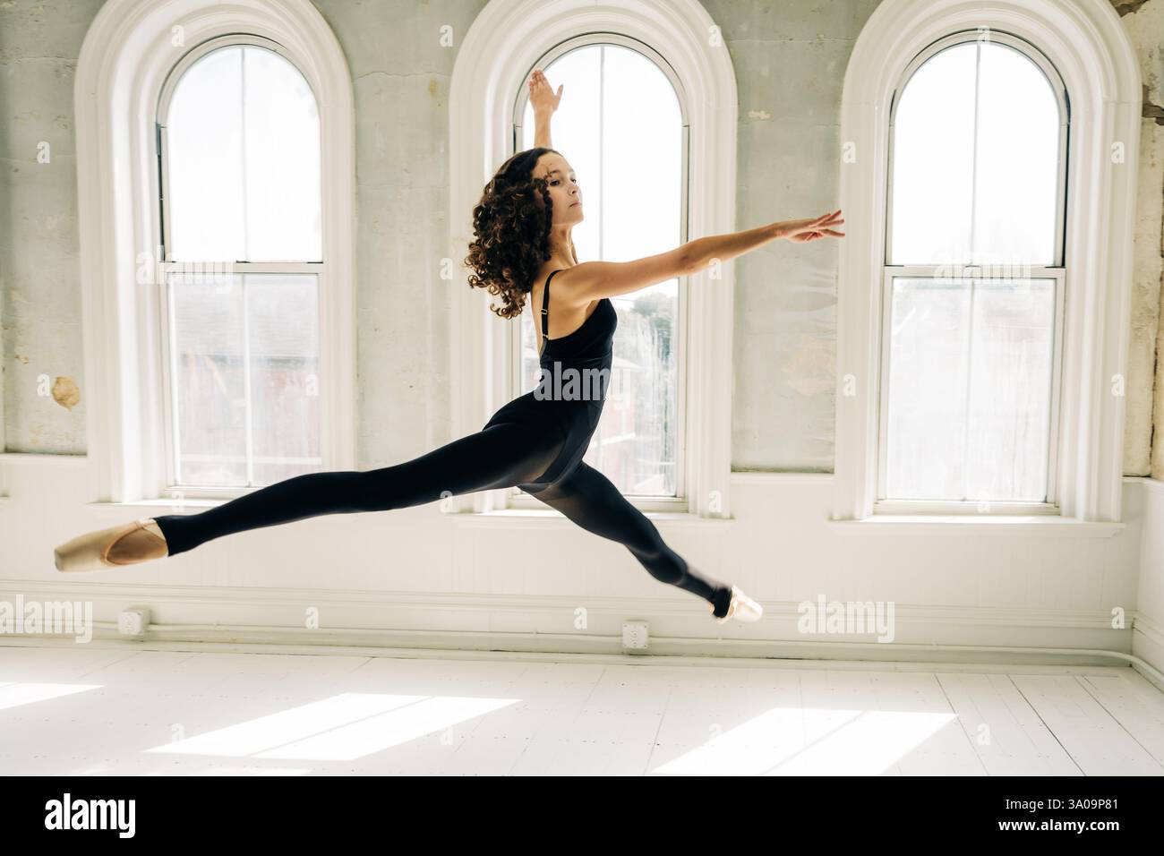 Ballet dancer mid-leap, displaying graceful form in a vintage studio ...