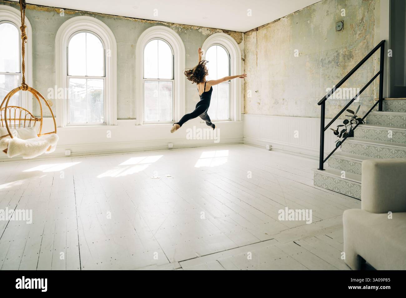 Ballet dancer leaps gracefully in a sunlit vintage dance studio Stock ...