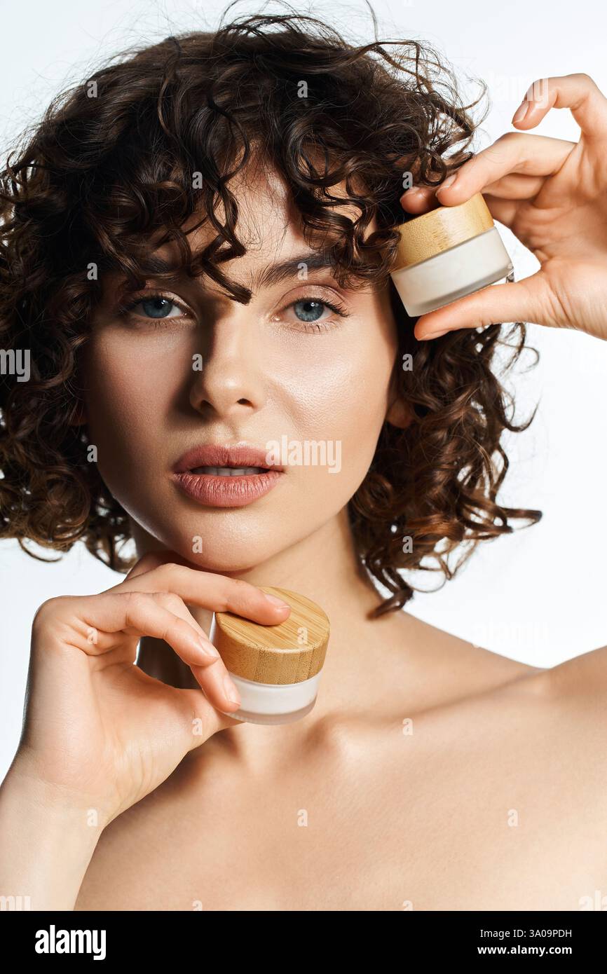 Young woman shows skincare jars, showcasing her glowing complexion and ...