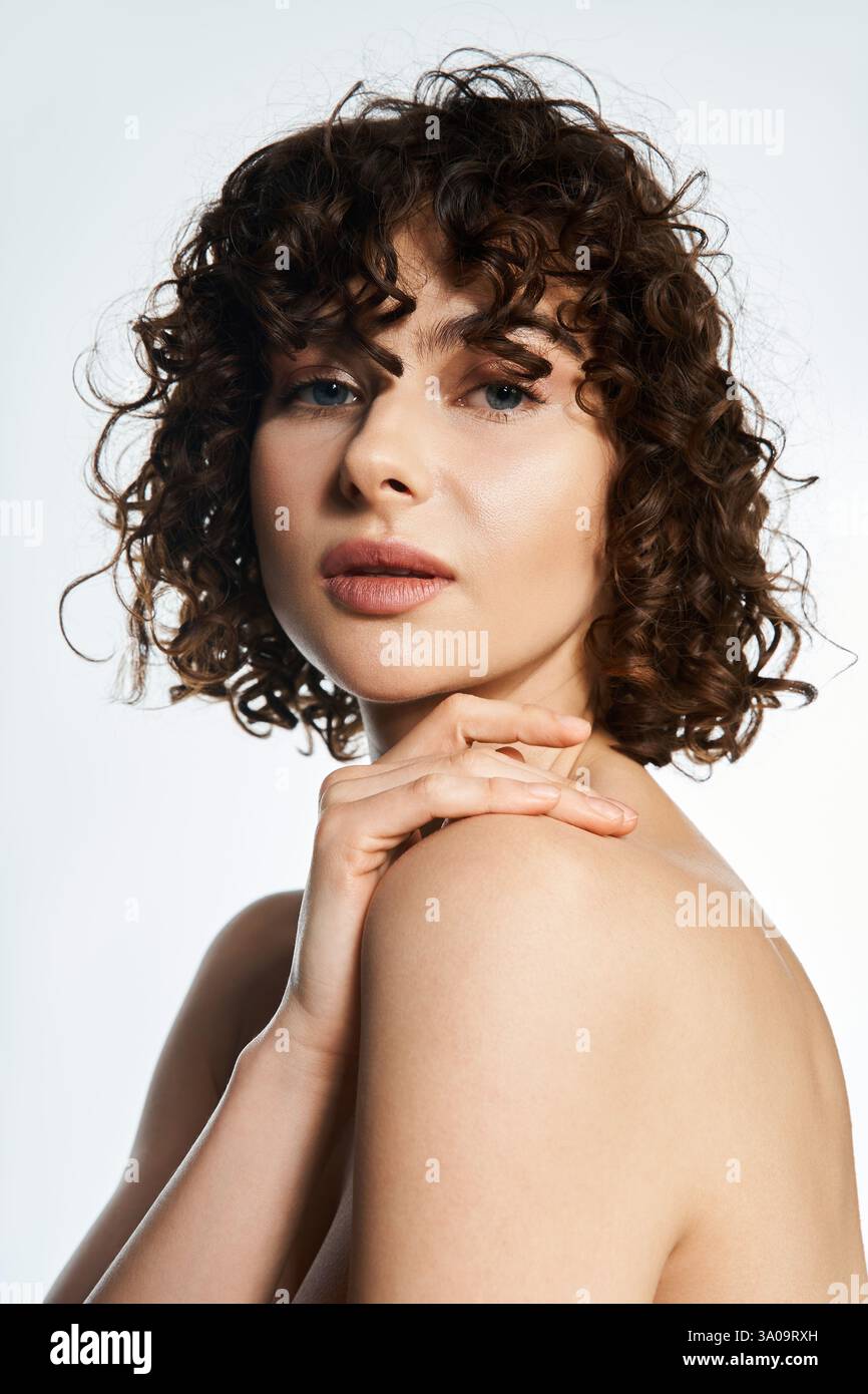 Young woman with gorgeous curls poses gracefully, showcasing her stunning features Stock Photo ...