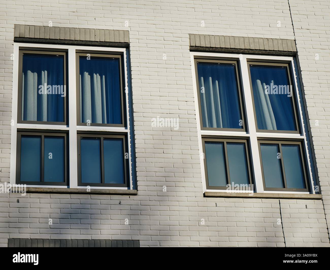 A close-up view of a modern residential facade featuring two large ...