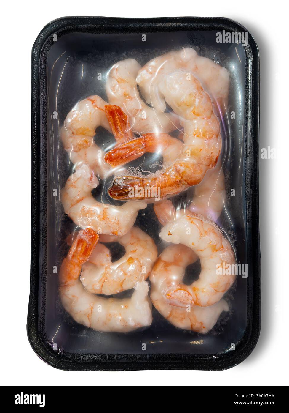 Frozen peeled shrimp packed in black plastic tray isolated on white ...