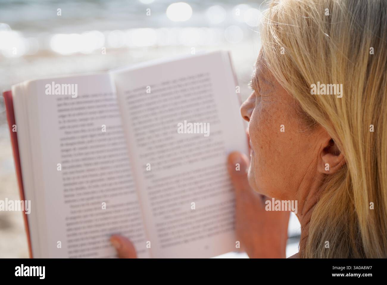 close up of a woman reading a book on the beach. World book day Stock ...