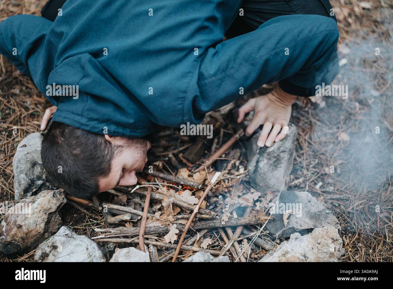 Man Starting a Campfire in a Forest Area Using Kindling and Sticks ...