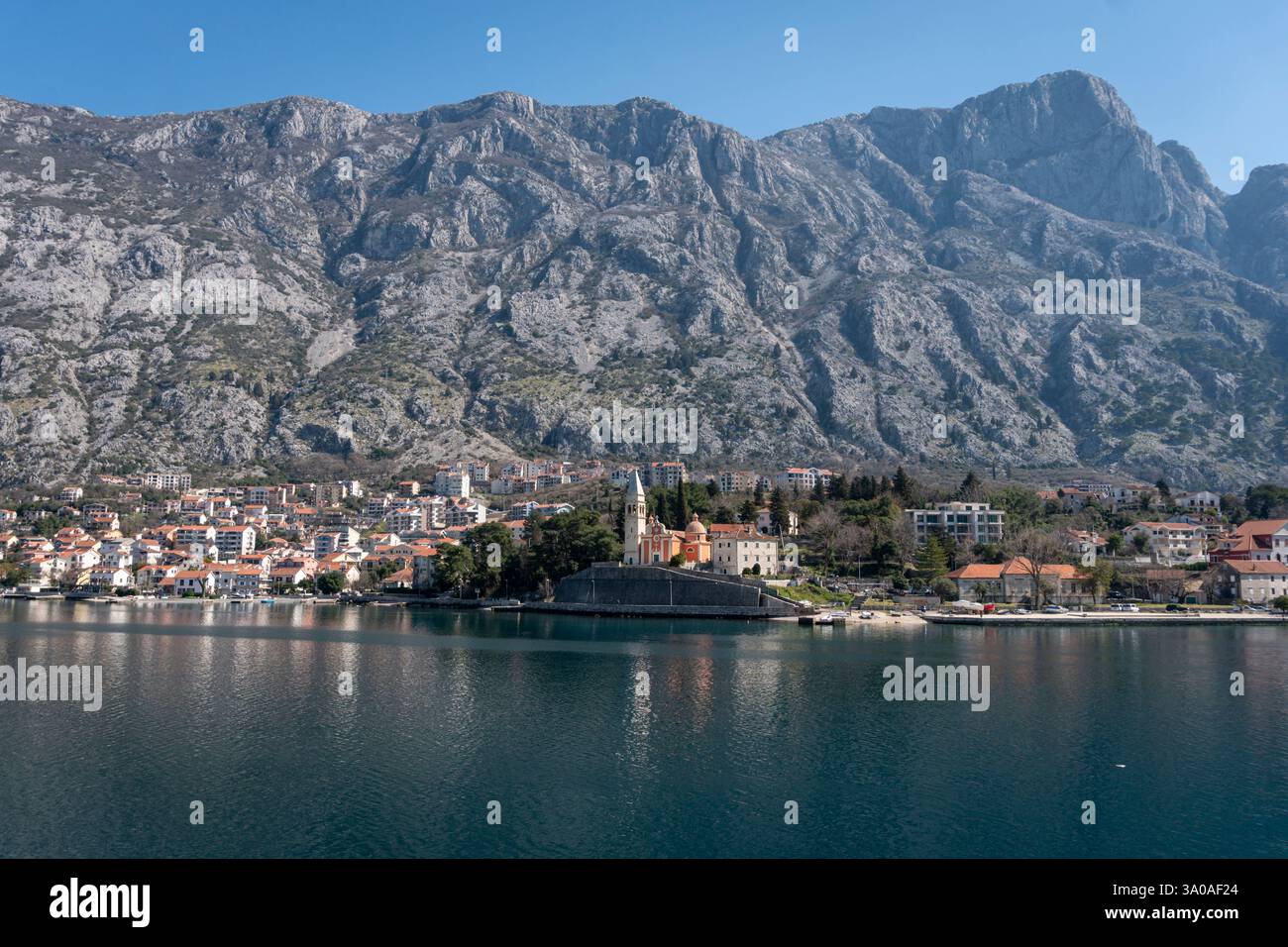 View of the small town of Dobrota with a backdrop of mountains in Kotor ...
