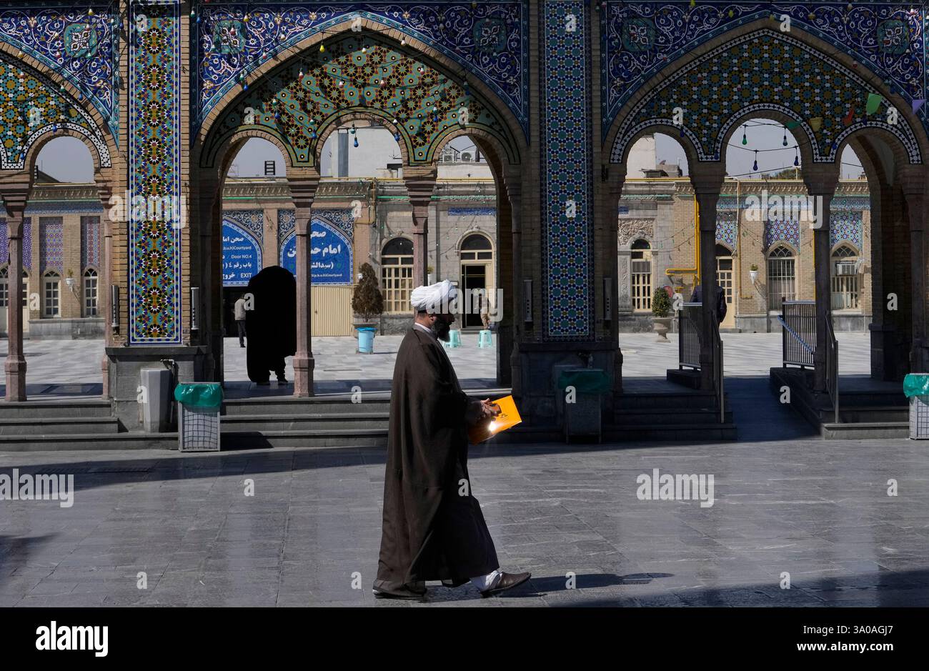 A cleric walks through the shrine of Shiite Saint Abdulazim, during the ...
