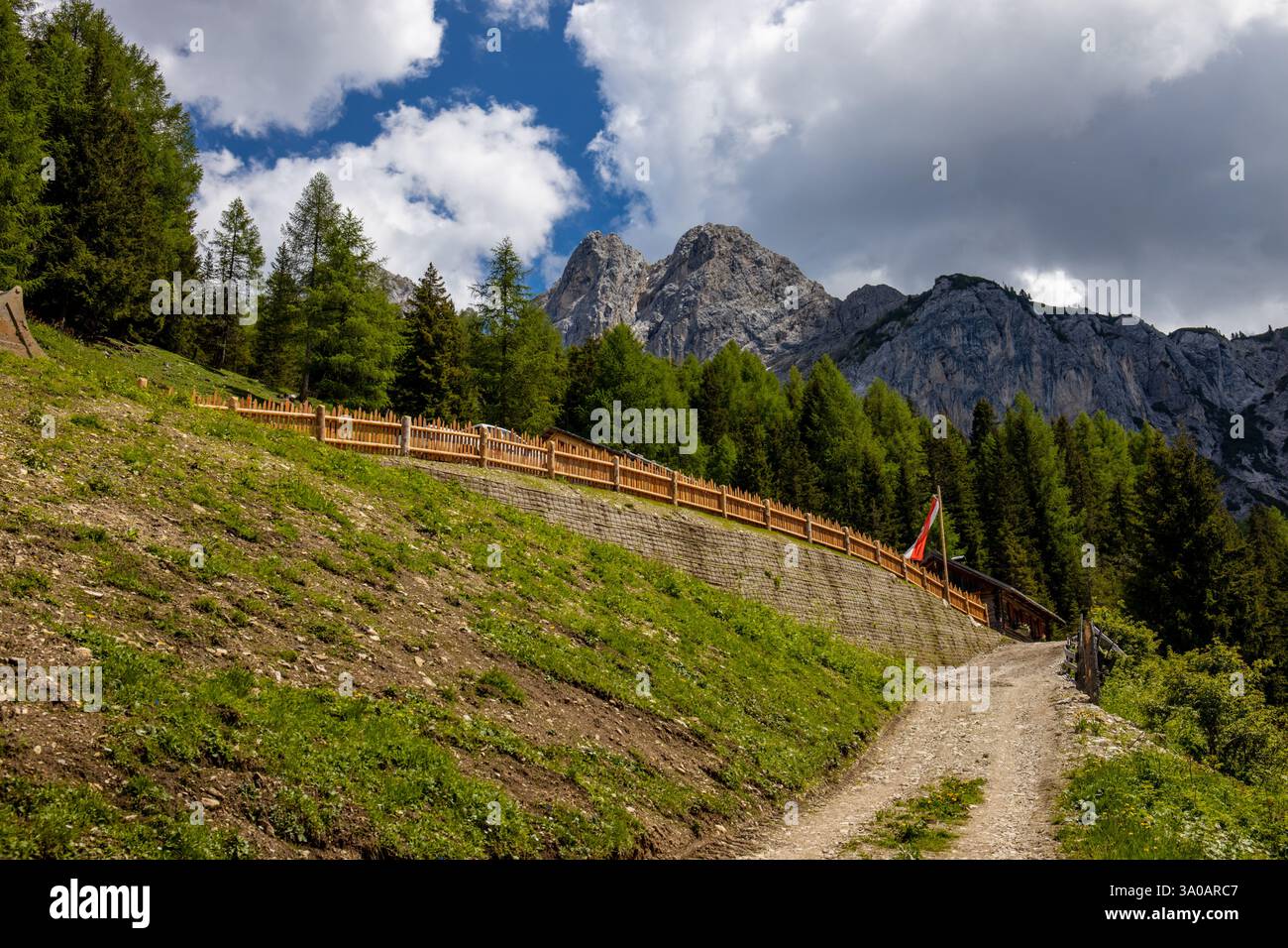 A mountain refuge at the base of rugged rock formations under a clear ...