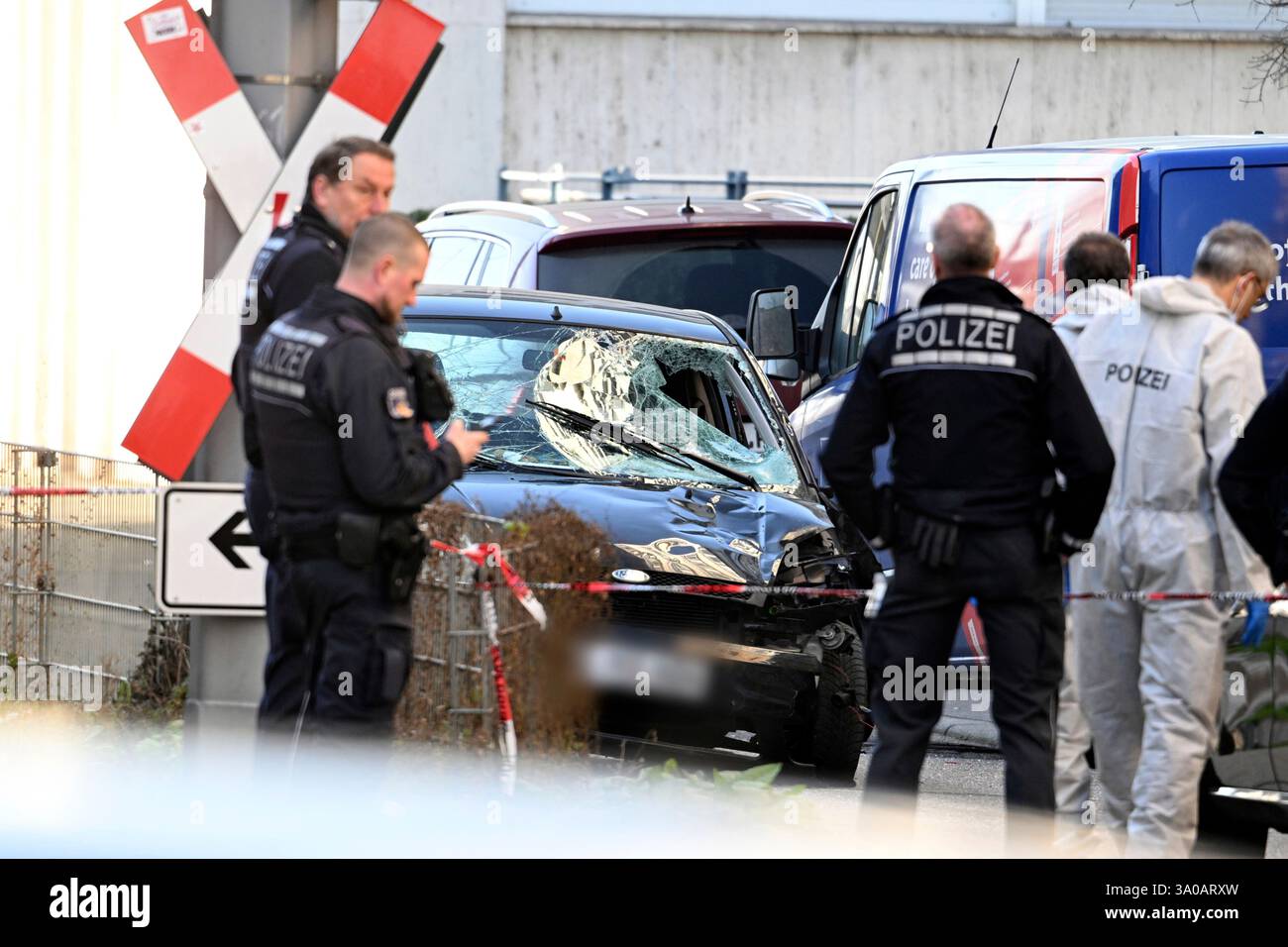 Police officers stand next to a damaged vehicle in the city center of ...