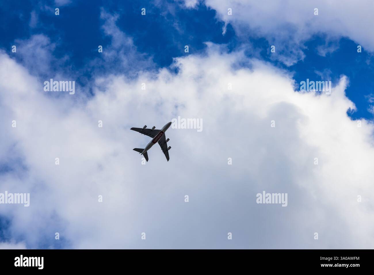 Emirates airplane flying high in the blue sky. London, UK, 29 July 2023 ...